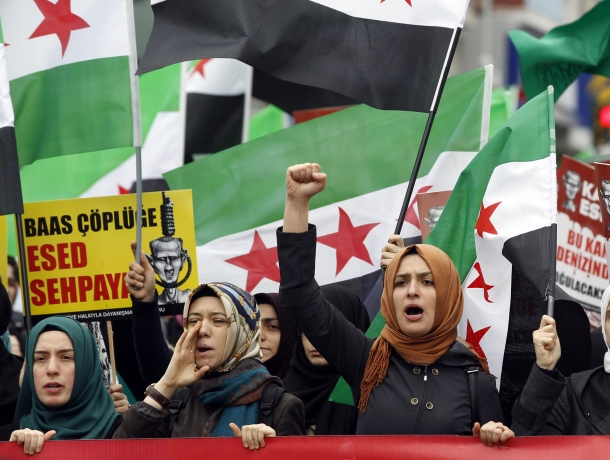 Sírios balançam bandeira usada pela oposição em al-Myassar, perto de ...